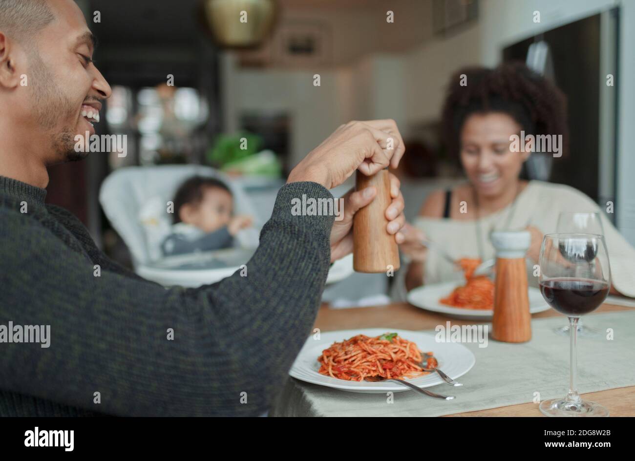Happy family enjoying spaghetti dinner at dining table Stock Photo - Alamy