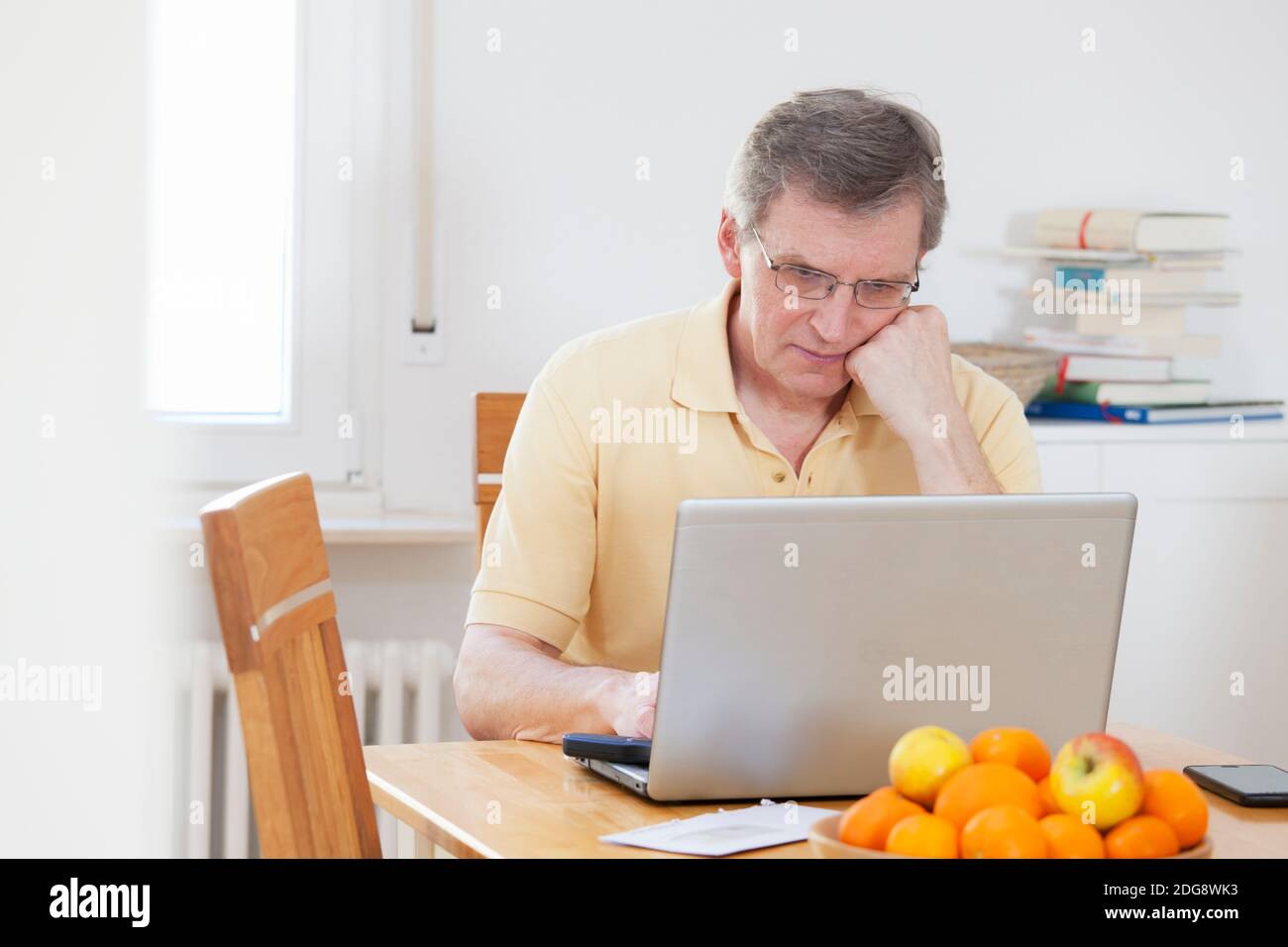 Mature tired man working with computer at home - focus on the head ...