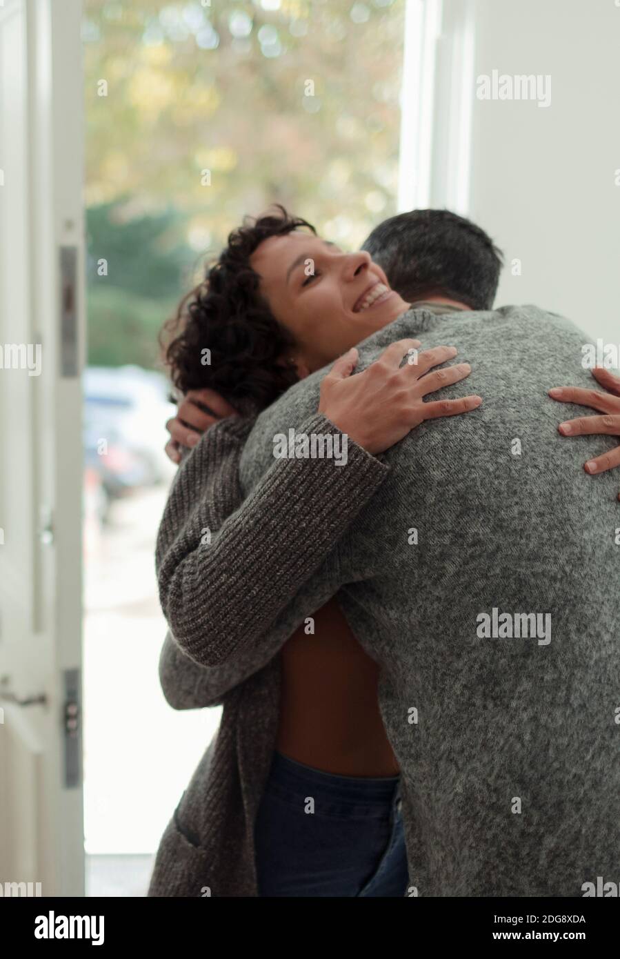 Couple hugging front door hi-res stock photography and images - Alamy