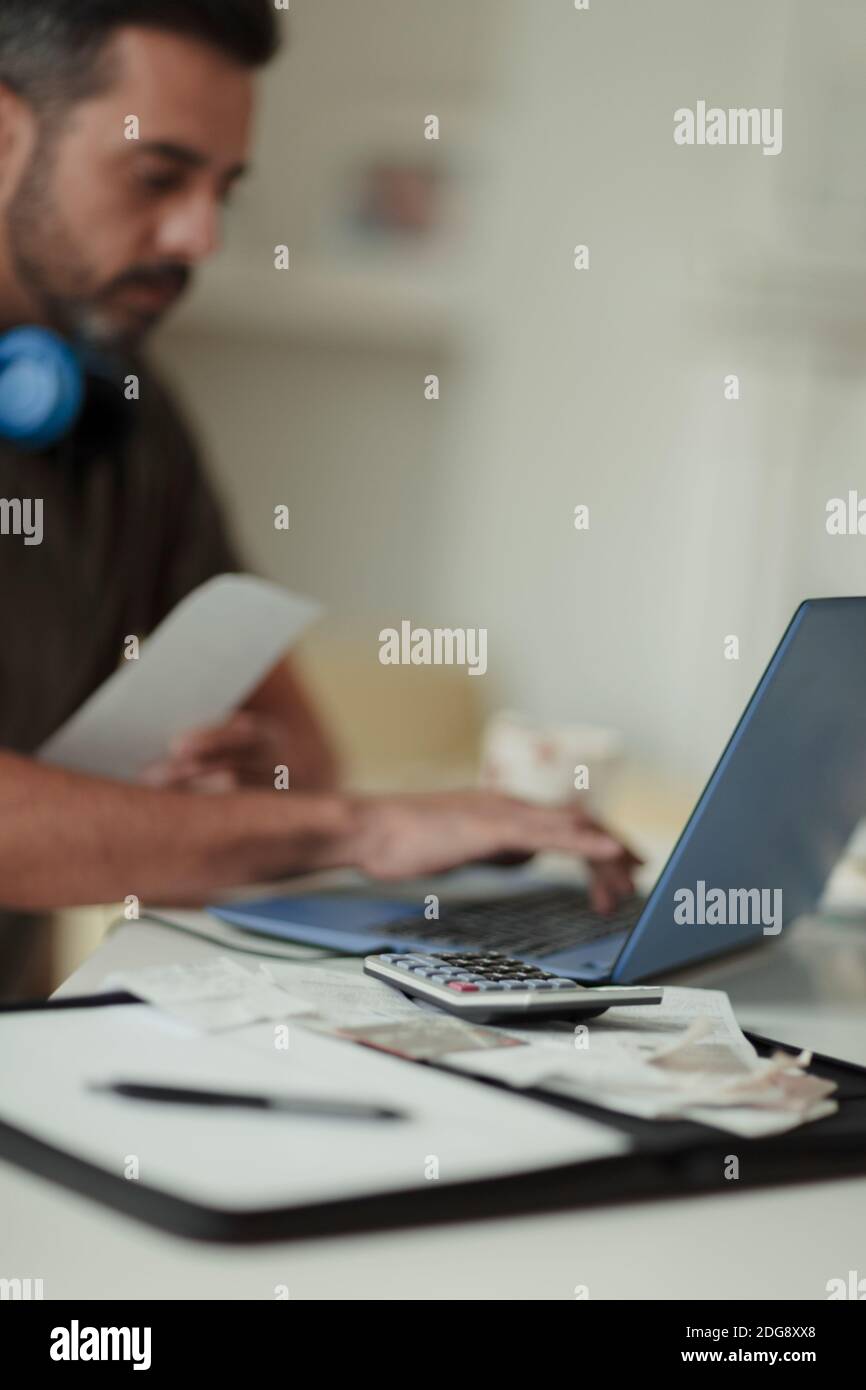 Man with receipts and calculator paying bills at laptop Stock Photo - Alamy