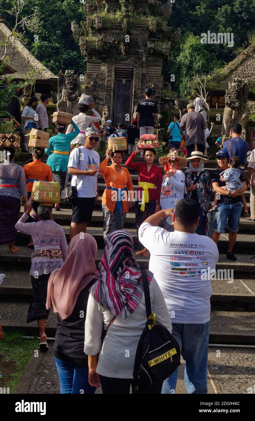 Tourists photographing a parade of women in traditional costumes ...