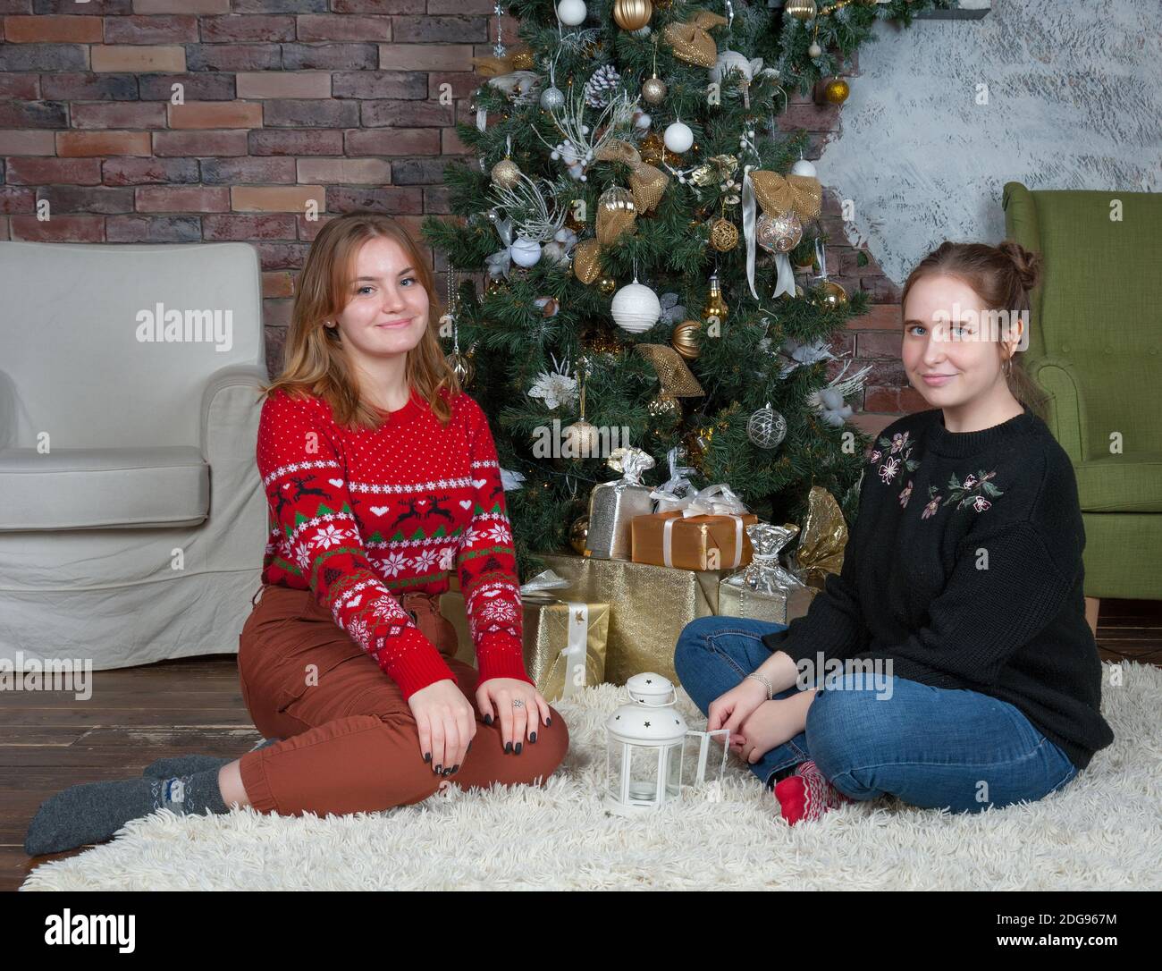 two joyful girls are sitting under a decorated Christmas tree Stock ... two joyful girls are sitting under a decorated Christmas tree Stock ...