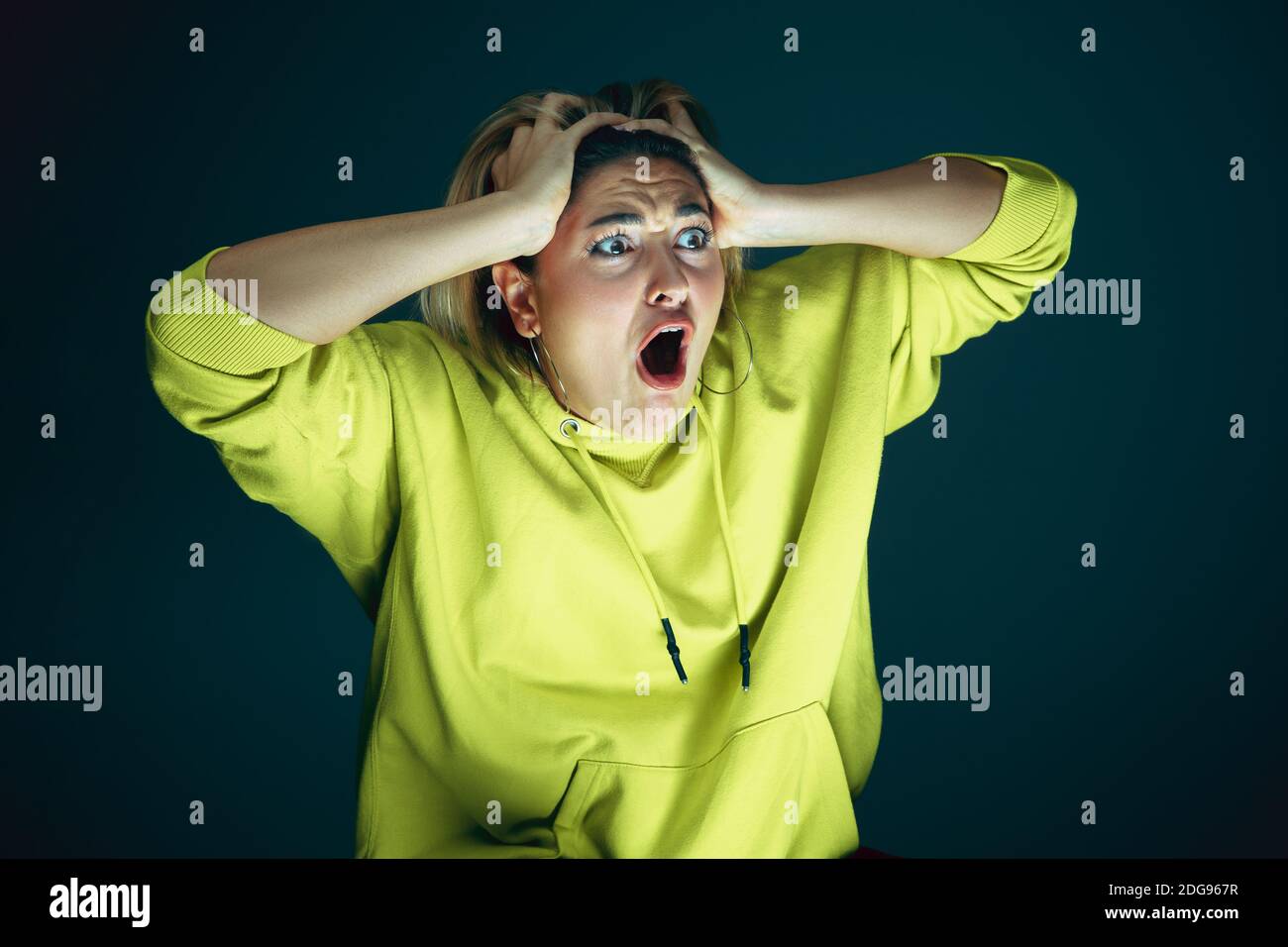 Holding head with hands. Portrait of young crazy scared and shocked ...