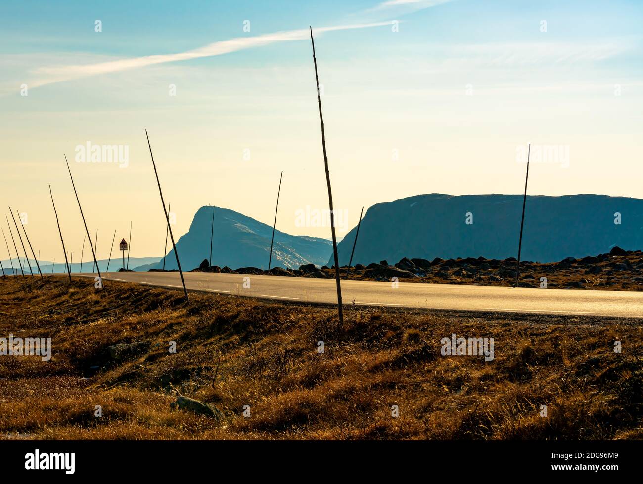 Long road in the mountains with road side marking sticks ready for ...