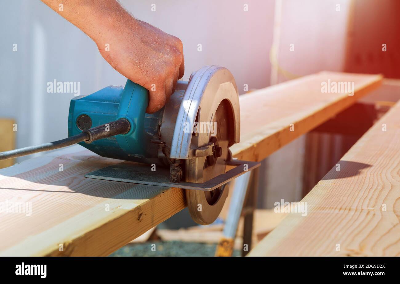 Cutting wood beam using an electrical chainsaw and professional tools ...