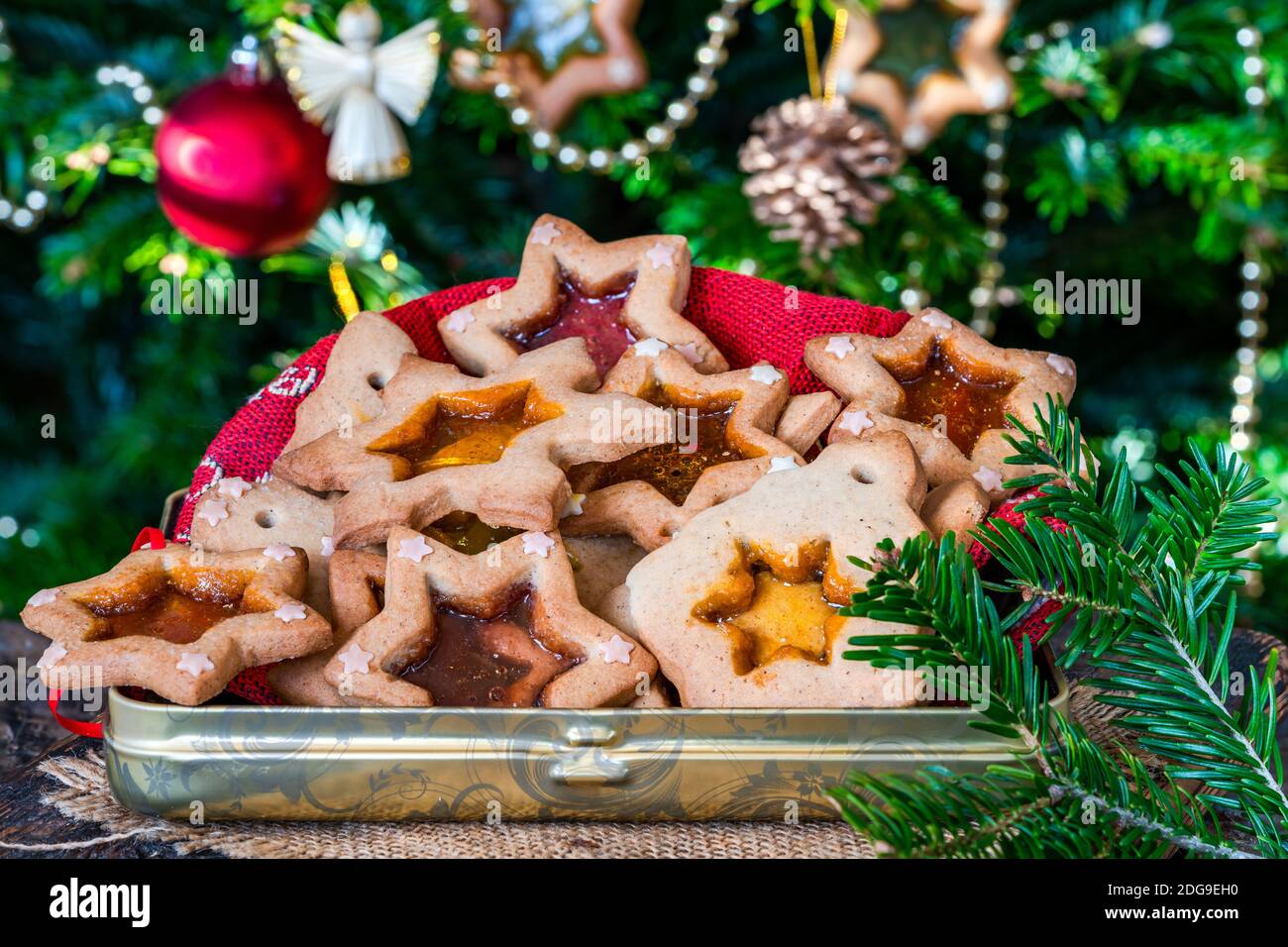 A pile of stained glass window biscuits on wooden table with Christmas ...