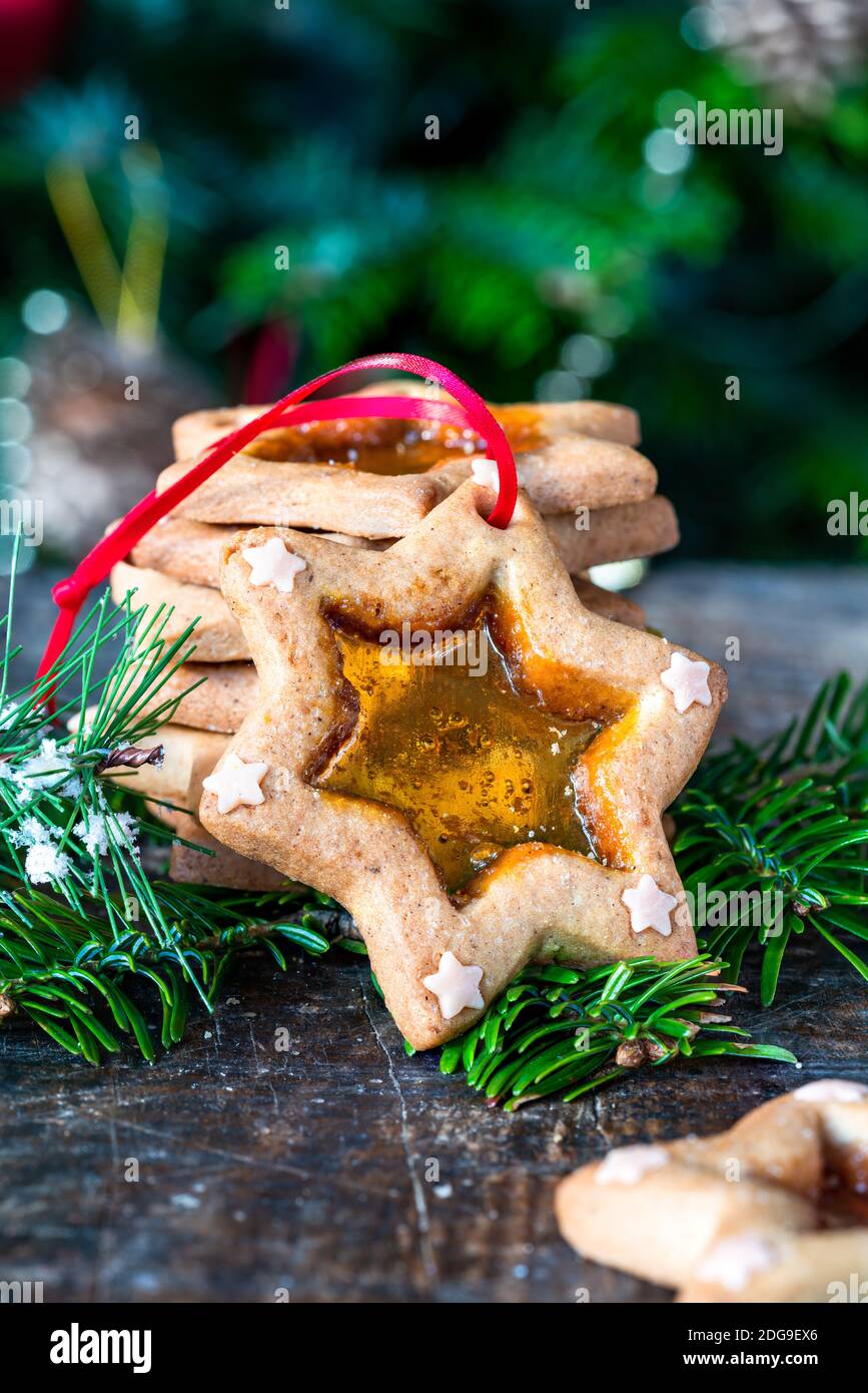 A pile of stained glass window biscuits on wooden table with Christmas ...