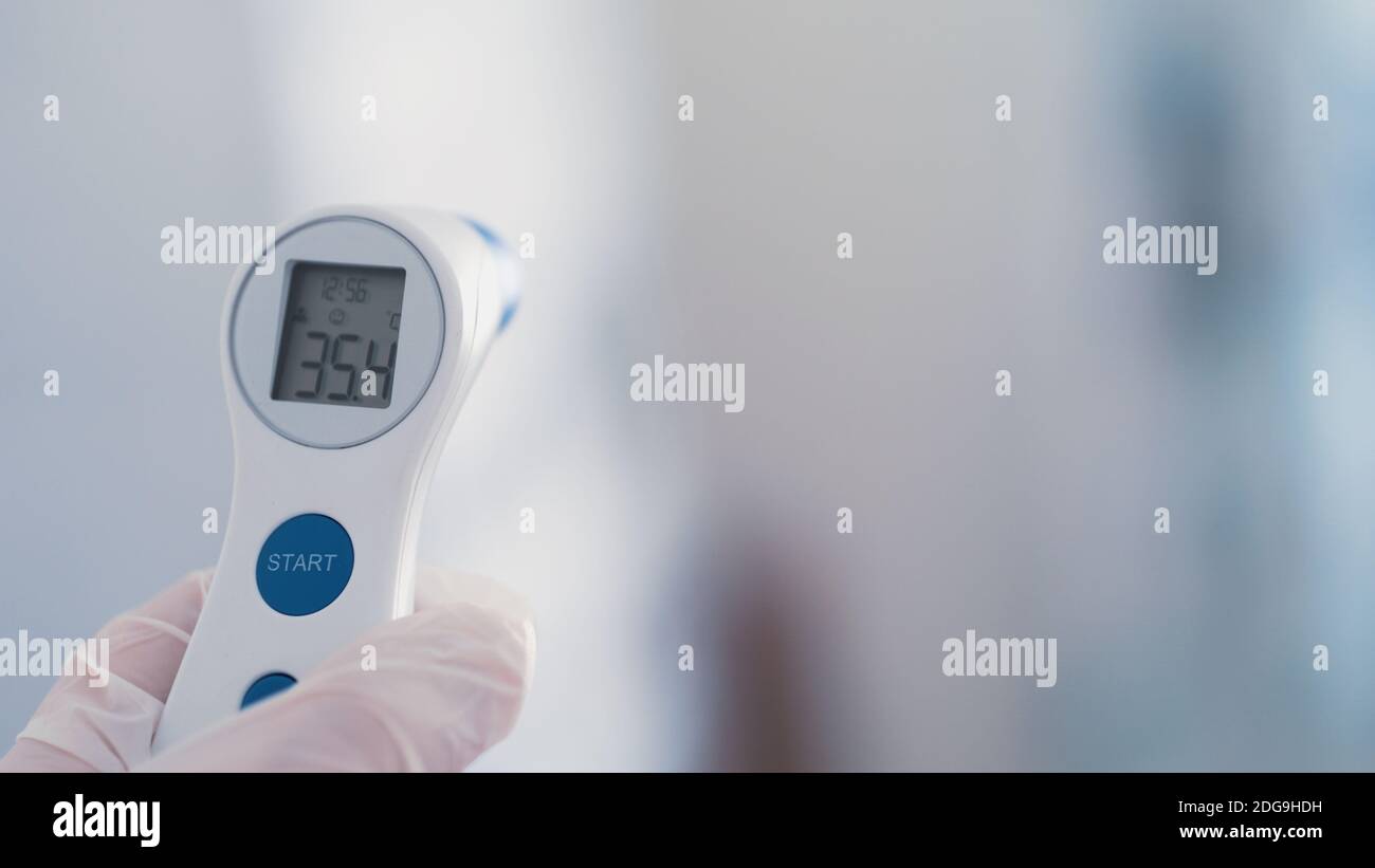 Man holding a non contact forehead temperature infrared thermometer ...