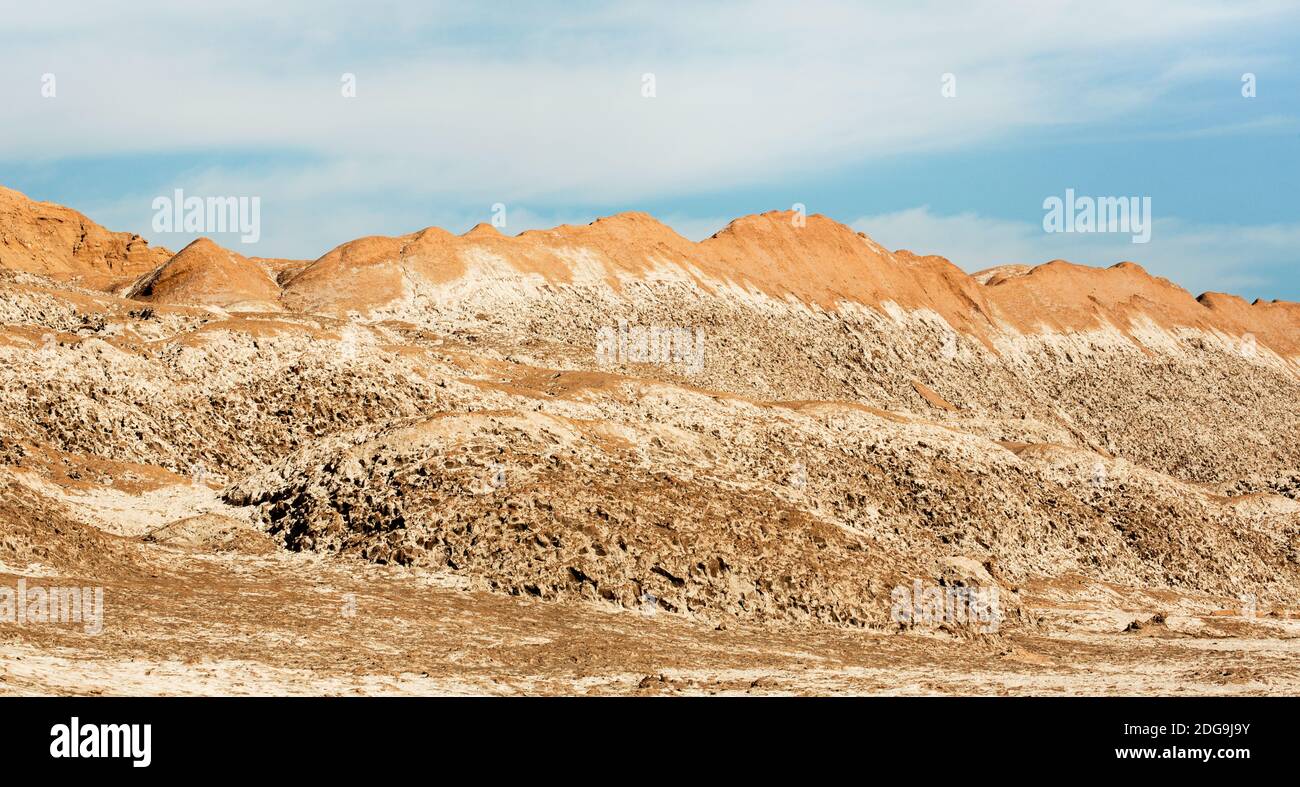 Eroded orange rocks and desert cliffs showing rock strata, in the Valle ...