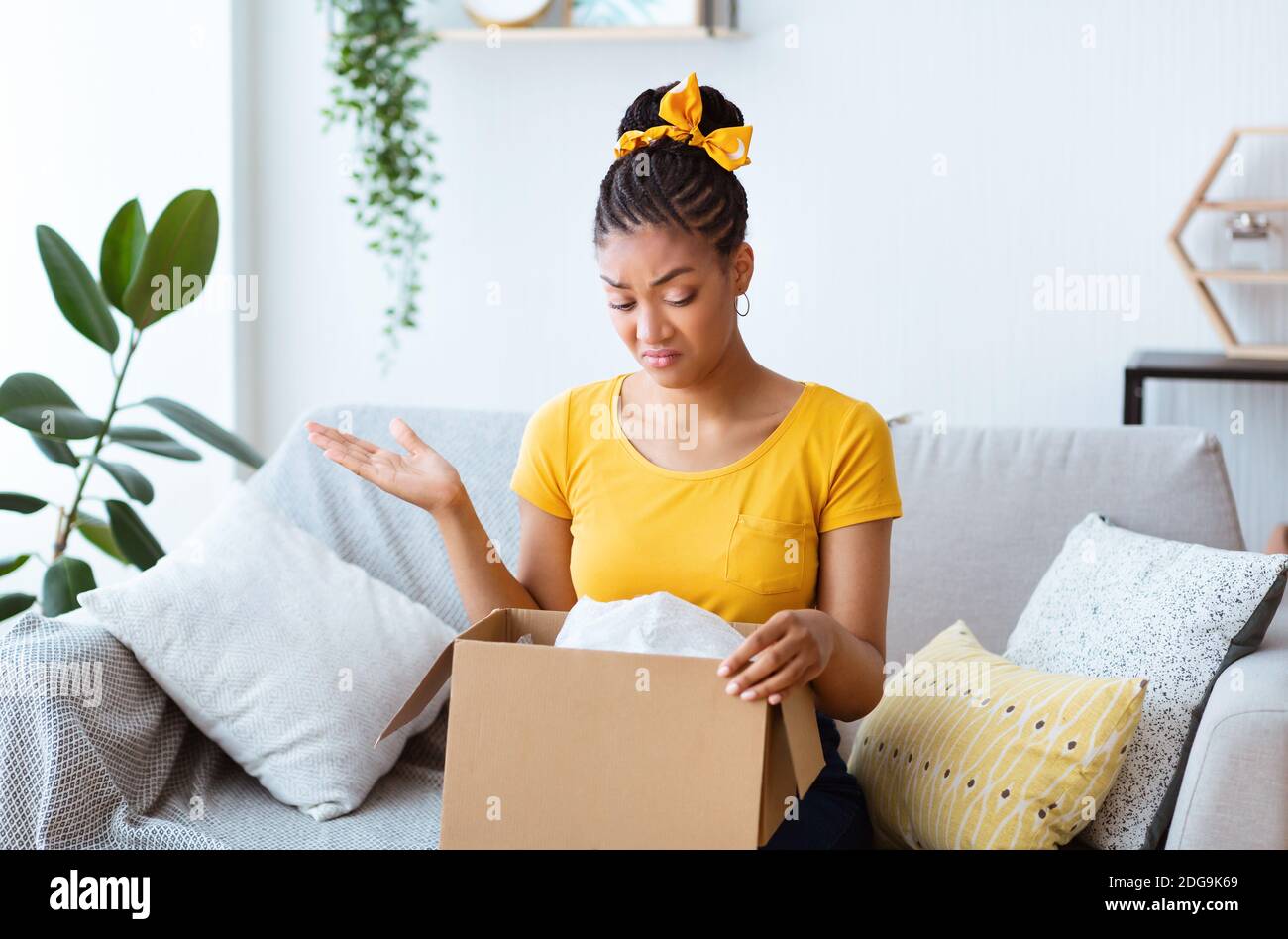 Frustrated black woman unpacking wrong box, delivery mistake Stock ...