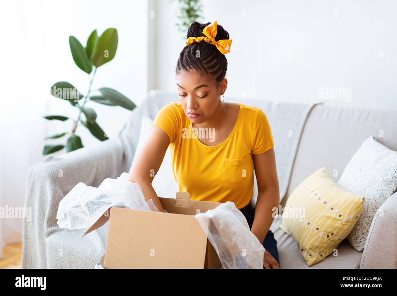 Frustrated black lady unpacking wrong parcel, delivery mistake Stock ...