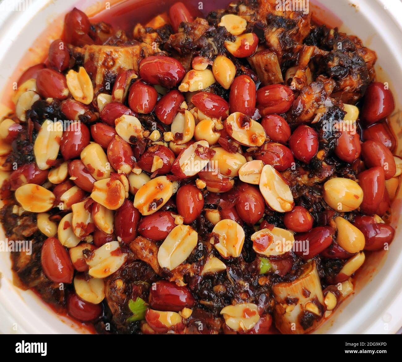 fresh fried peanuts in the red spicy oil in the white bowl Stock Photo ...