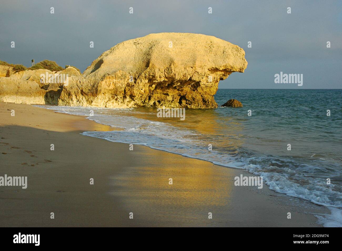Peculiar yellow eroded rock formations, yellow sand beach and shallow ...