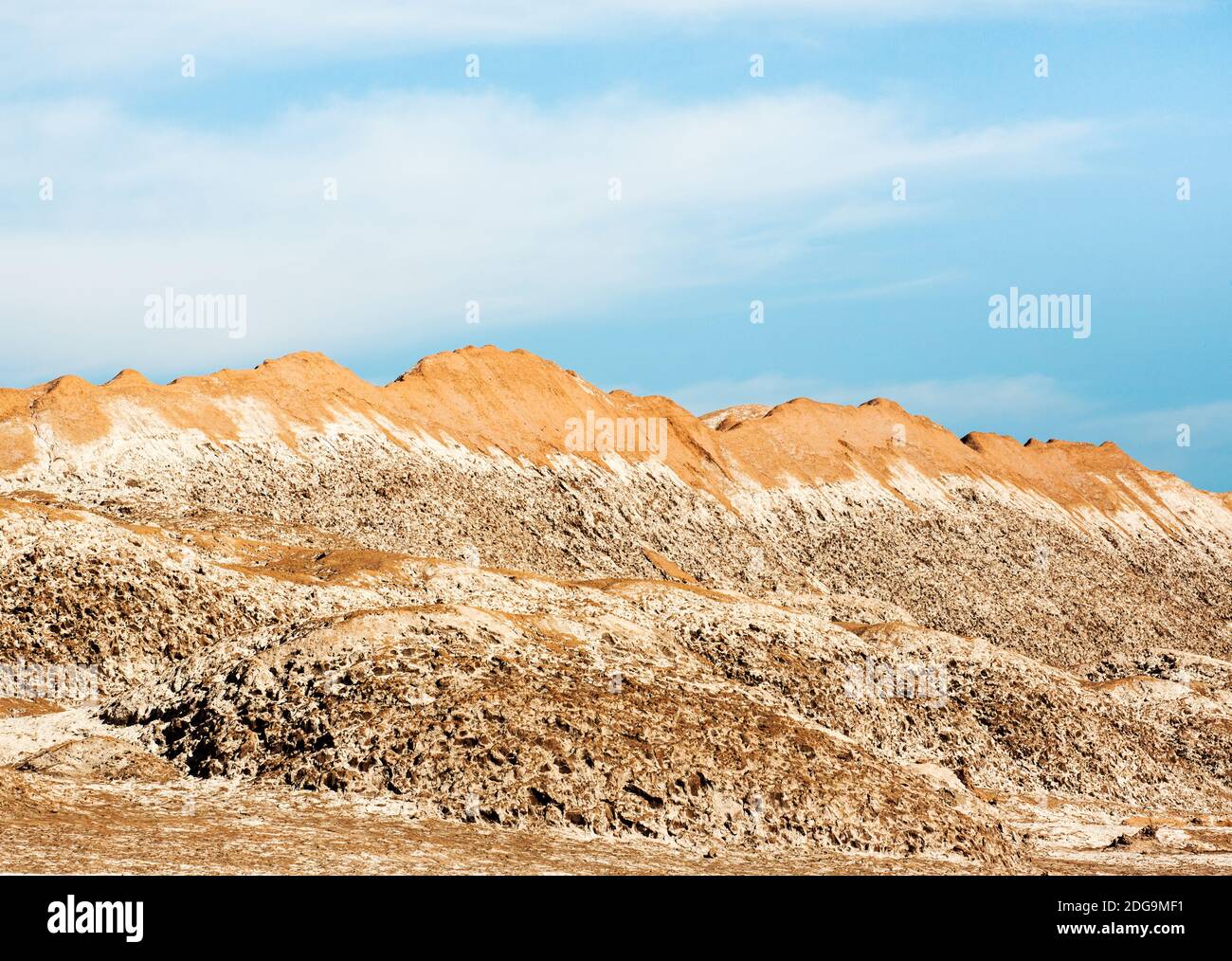 Eroded orange rocks and desert cliffs showing rock strata, in the Valle ...