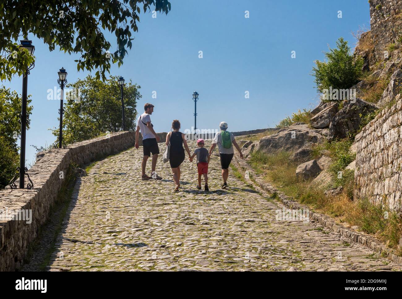 Family walking up stone path hill Stock Photo - Alamy