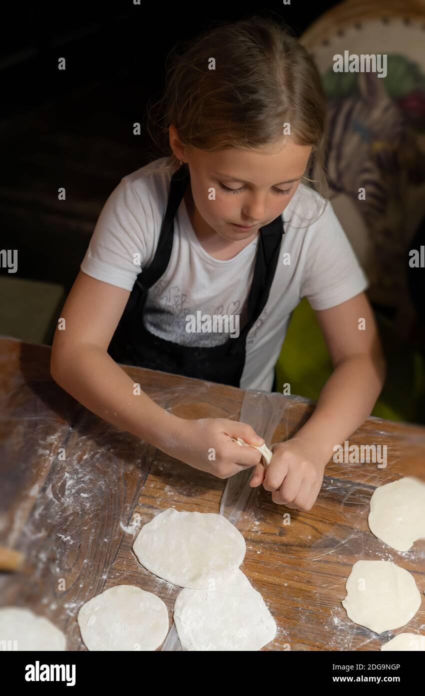 Caucasian girl child learning the art of making of traditional chinese ...