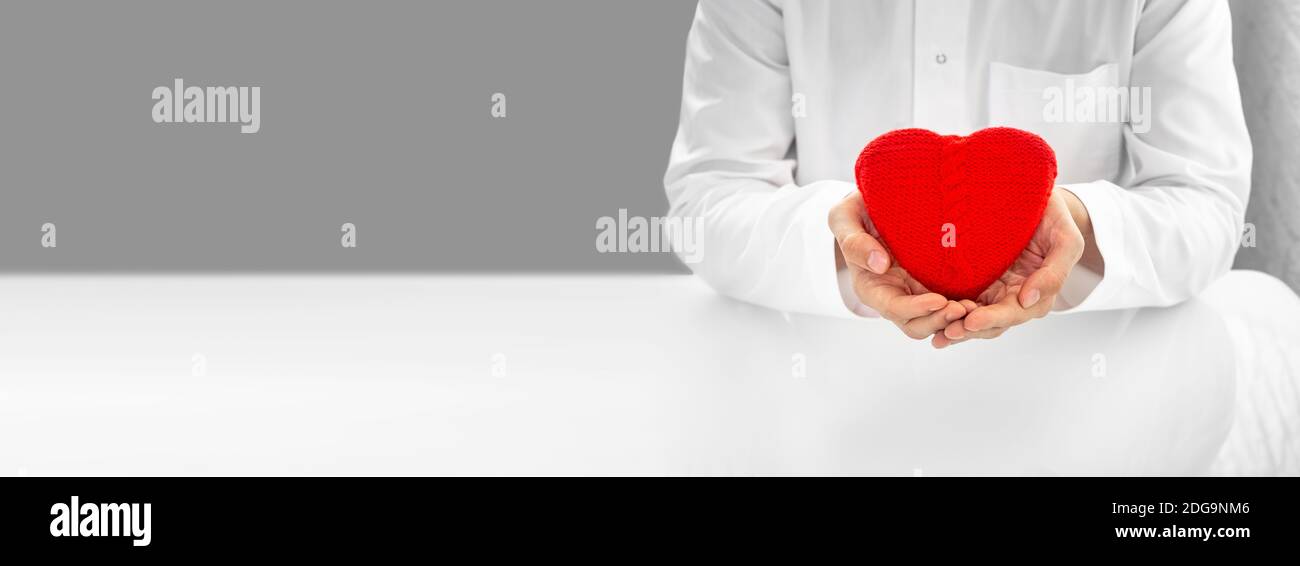Cardiologist holds a red heart visual model. Heart health concept in ...