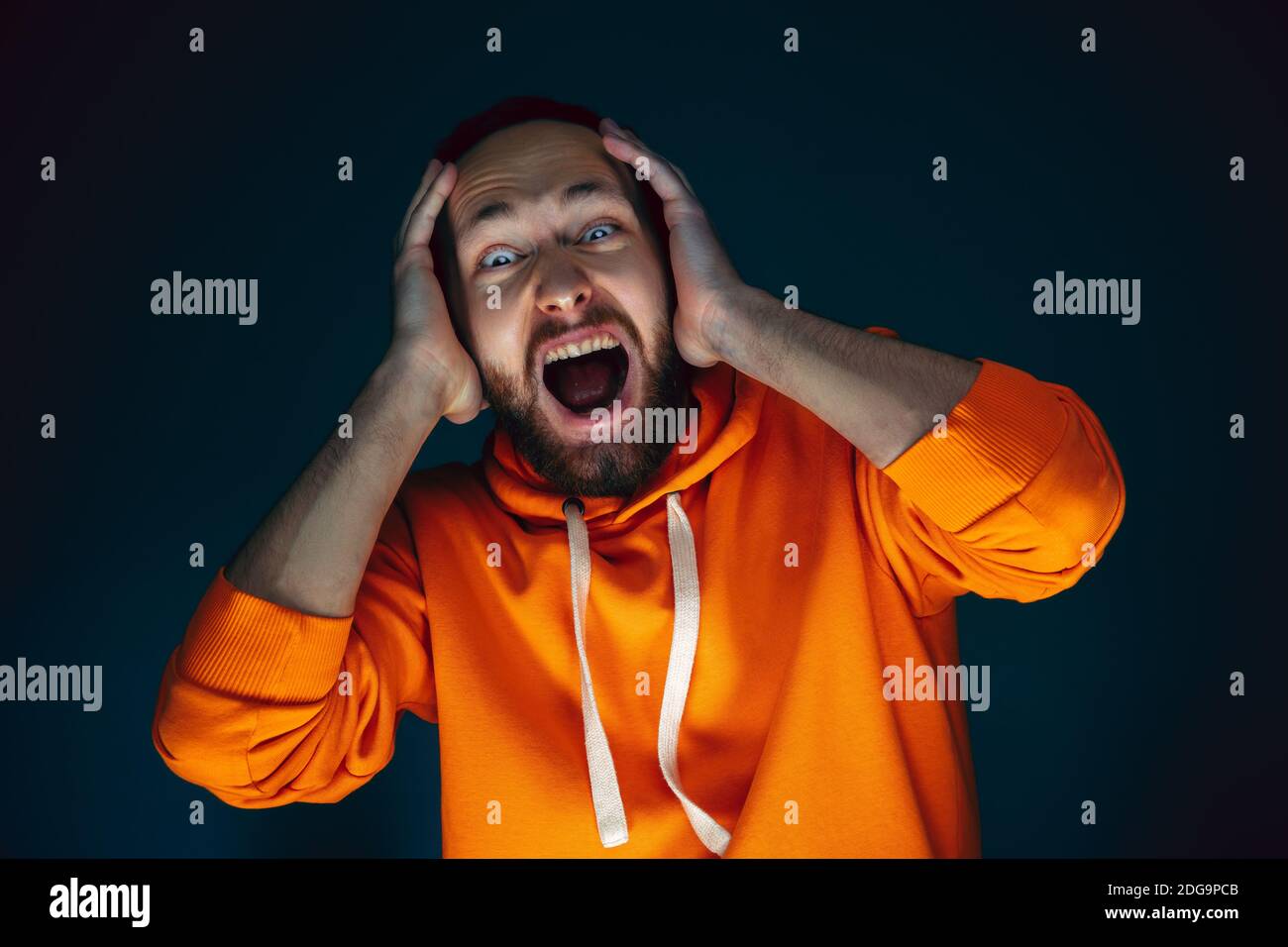 Closing ears. Portrait of crazy scared and shocked caucasian man ...