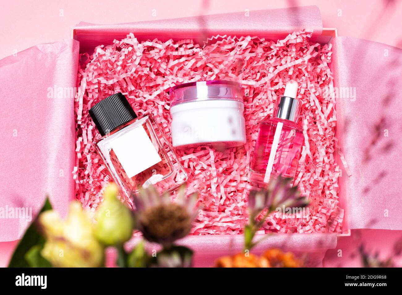 Beauty box with cosmetics filled with shredded pink paper packing ...