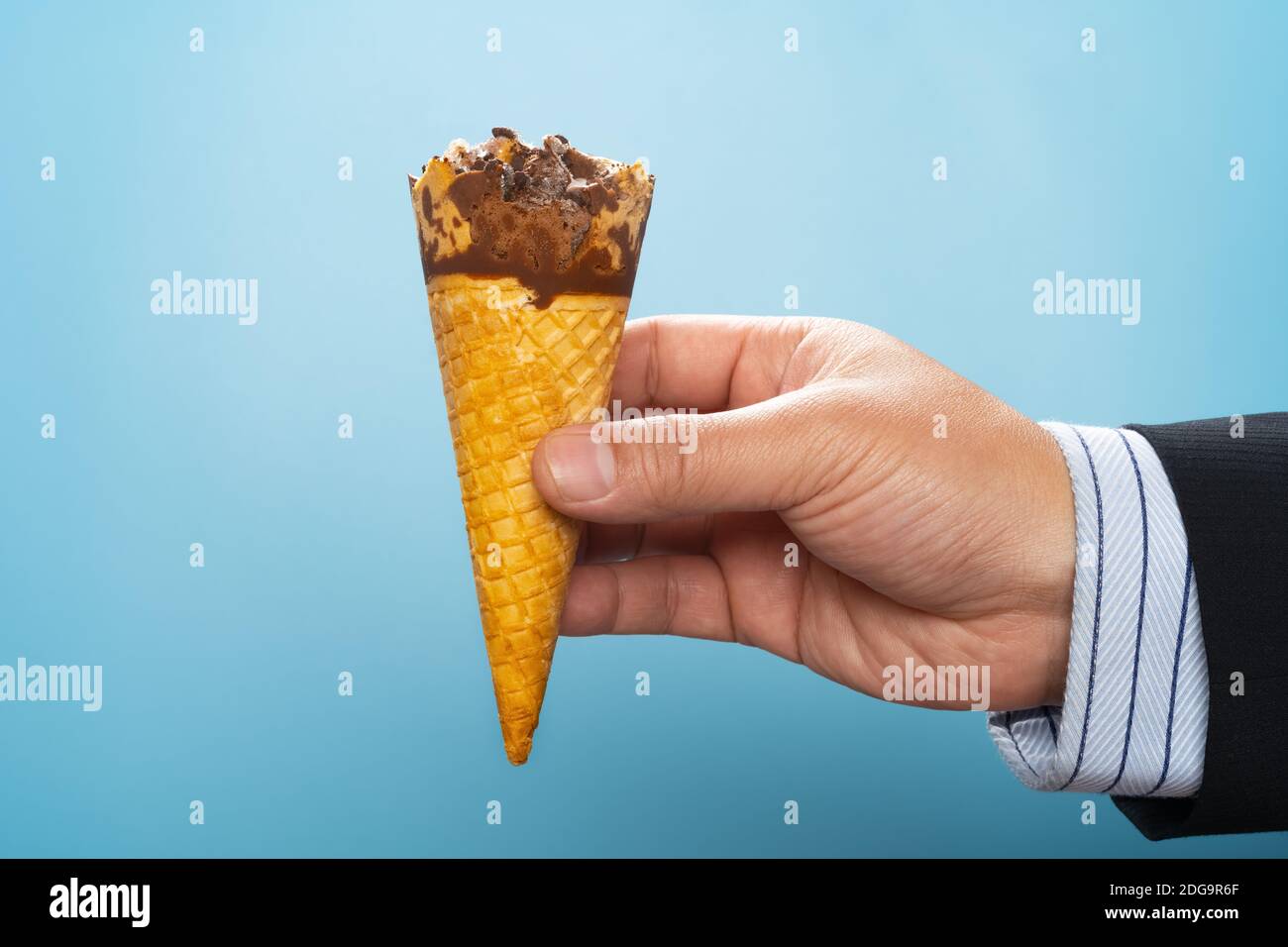 man in suit holding a coffee flavor ice cream cone with chocolate on ...
