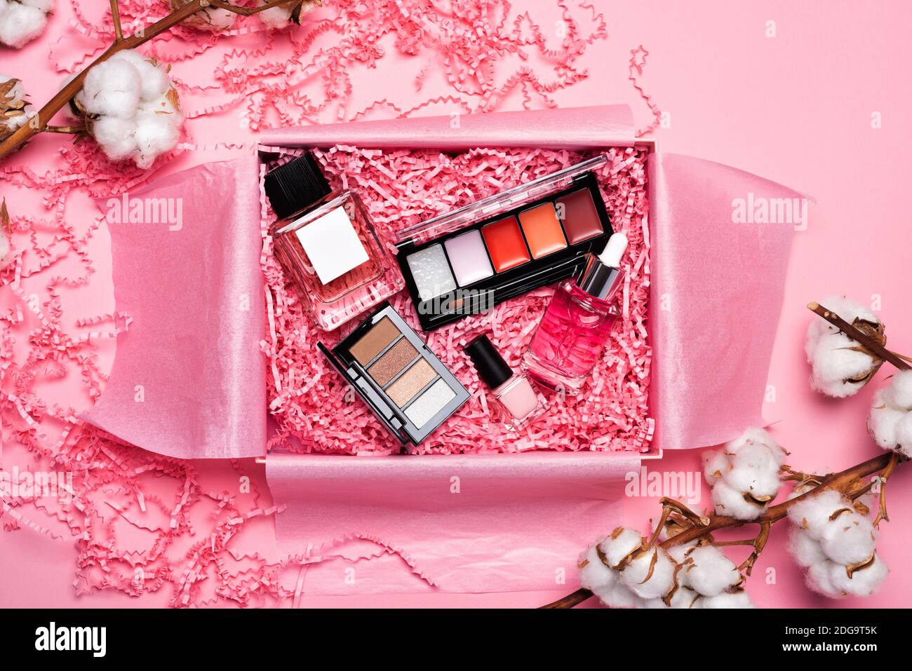Beauty box with makeup cosmetics filled with shredded pink paper ...