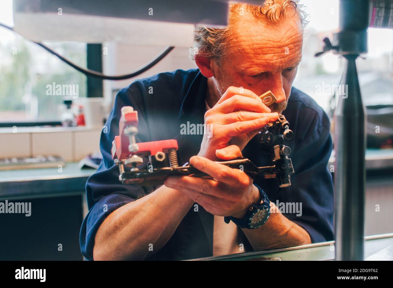 Old man working with diamond tools and with a magnifying glass. Diamond ...