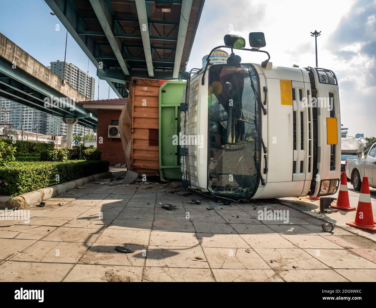 A truck carrying a container overturned on a road under a bridge over ...