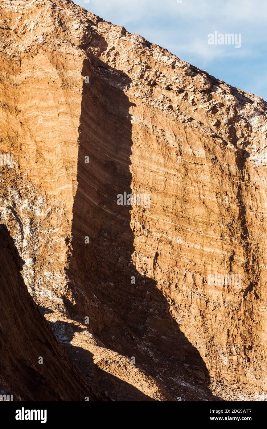 Eroded orange rocks and desert cliffs showing rock strata, in the Valle ...