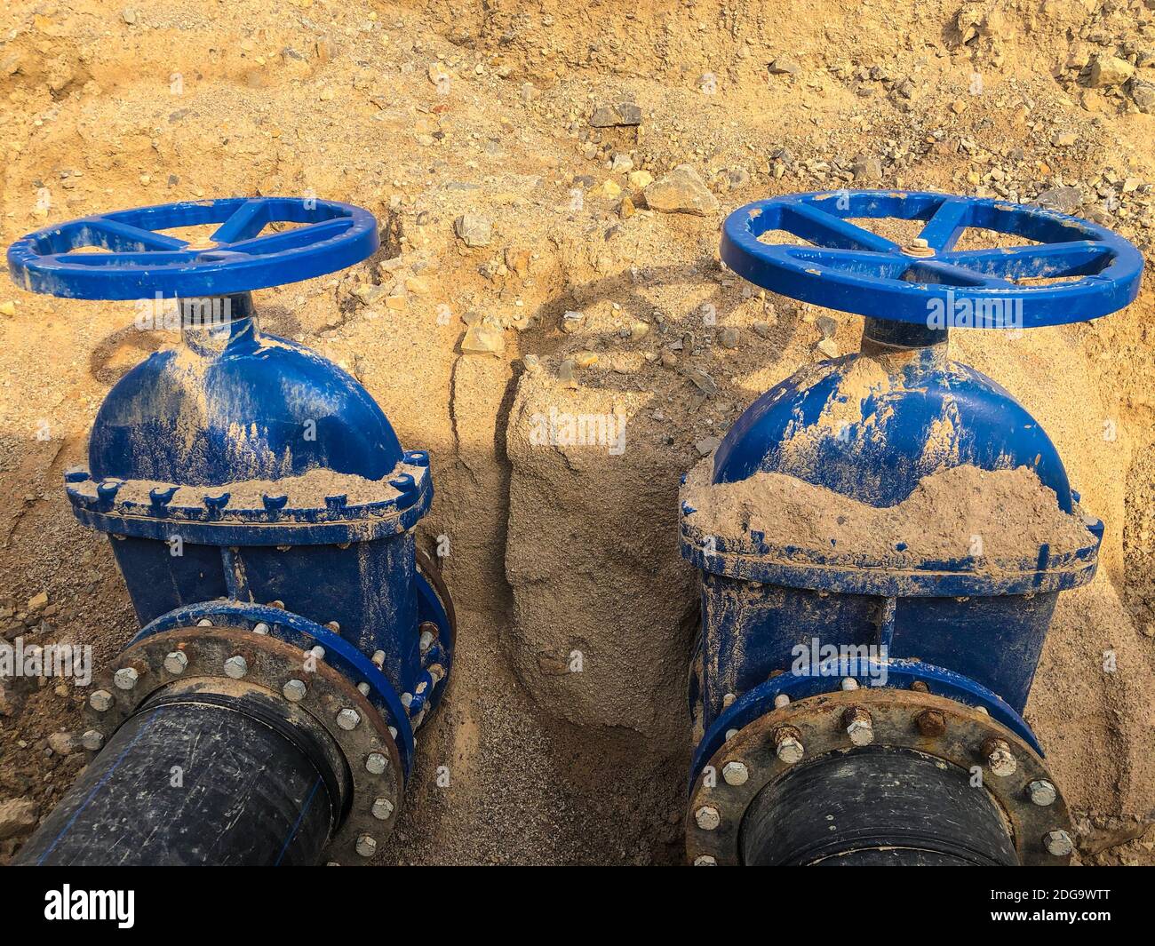 Valves on pipeline in ground. Pipe valves in trench Stock Photo - Alamy
