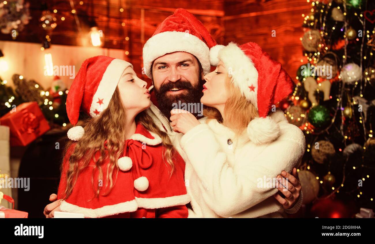 Lovely daughter with parents wearing Santa hat. Being best Santa for ...