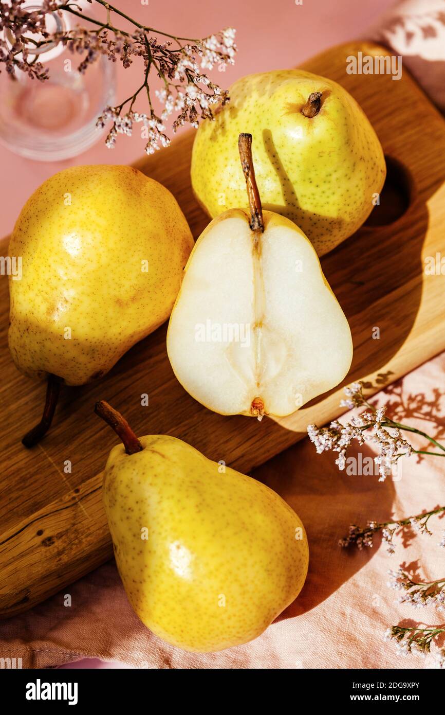 Still life of yellow pears on a pink background. Pears and pears in the ...