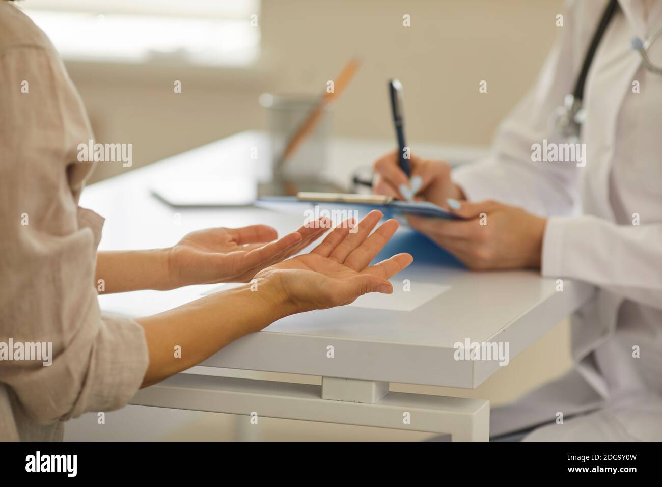 Doctor patient hands table hi-res stock photography and images - Alamy