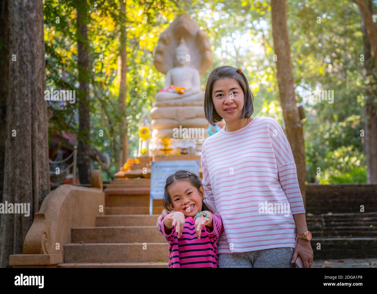 Tourist Asian mother and daughter in front of blurred white Buddha ...