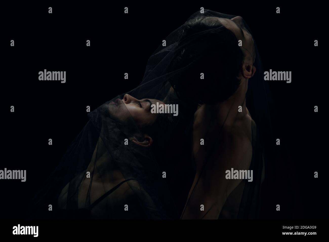 Dark. Graceful classic ballet dancers isolated on black studio ...