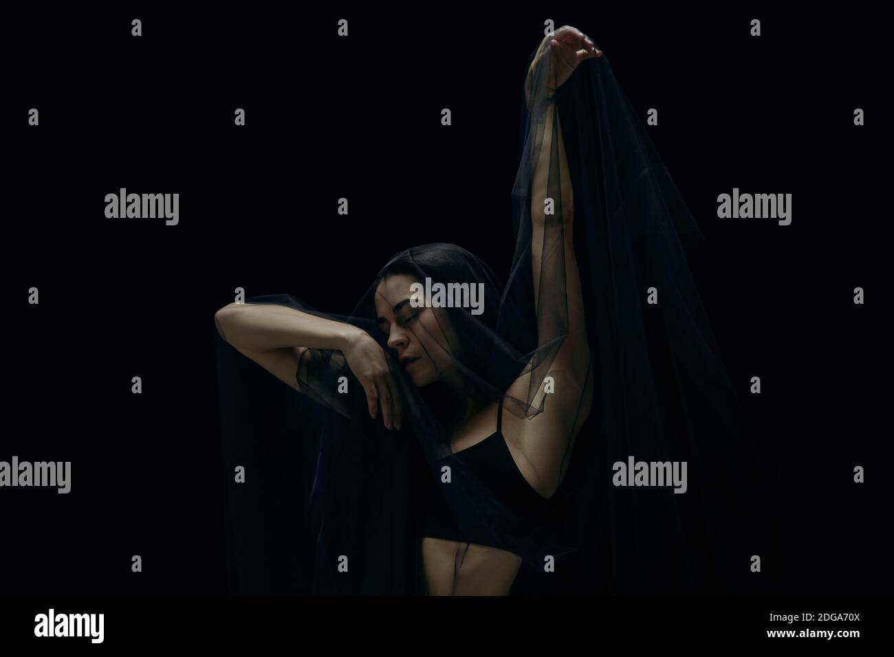 Scared. Graceful classic female ballet dancer isolated on black studio ...