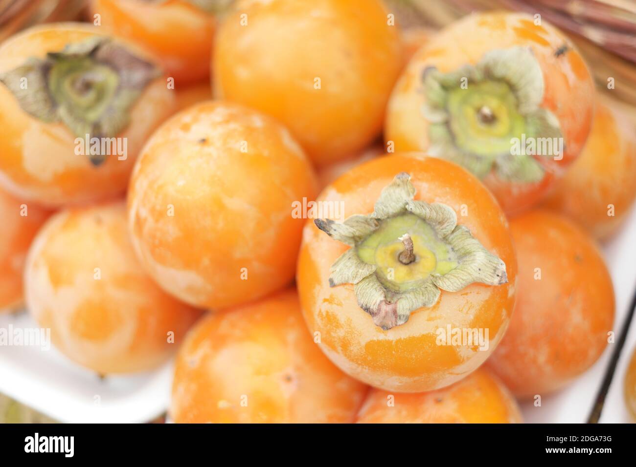 Heap of persimmon fruits close up Stock Photo - Alamy
