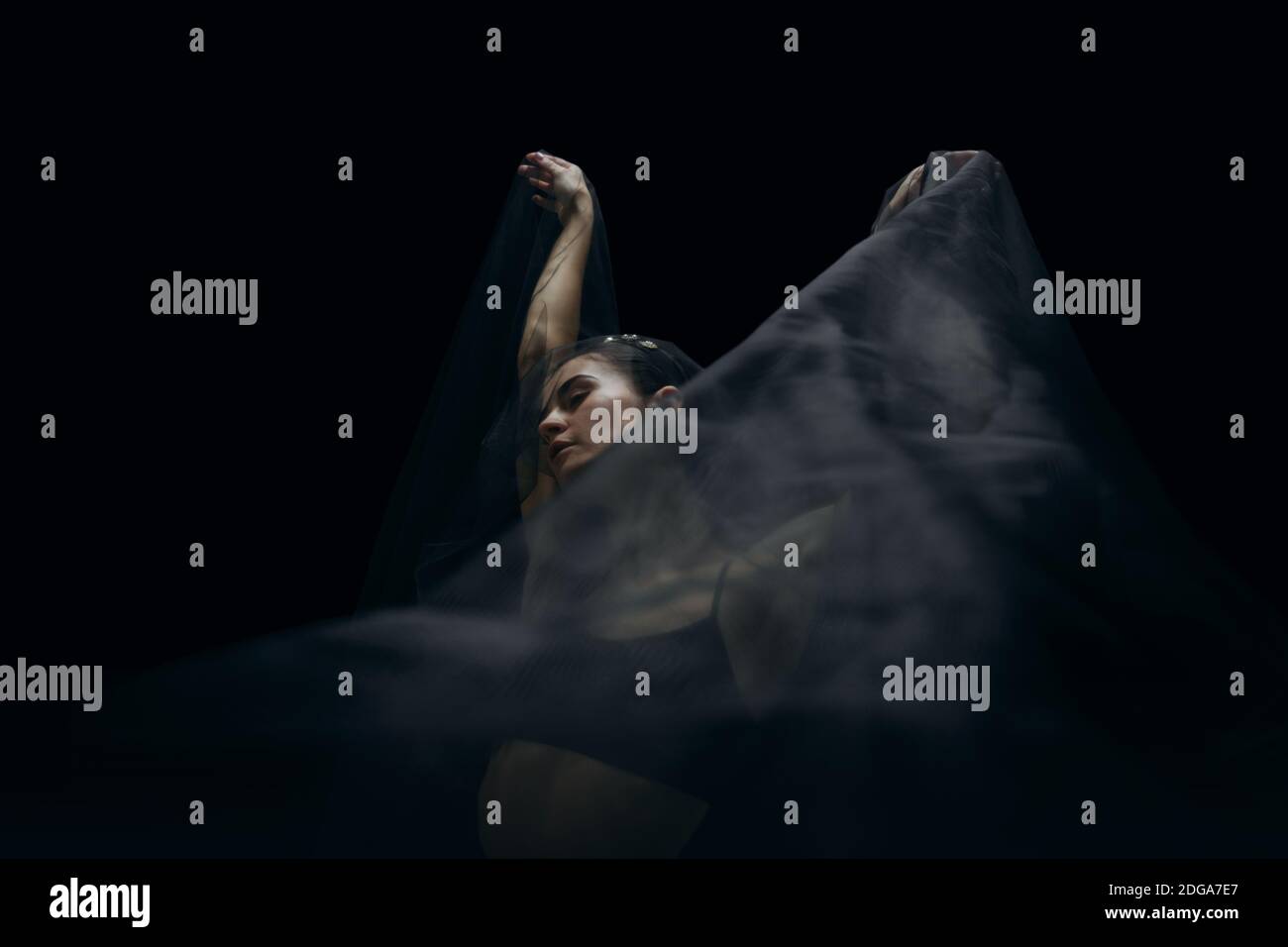 Falling. Graceful classic female ballet dancer isolated on black studio ...