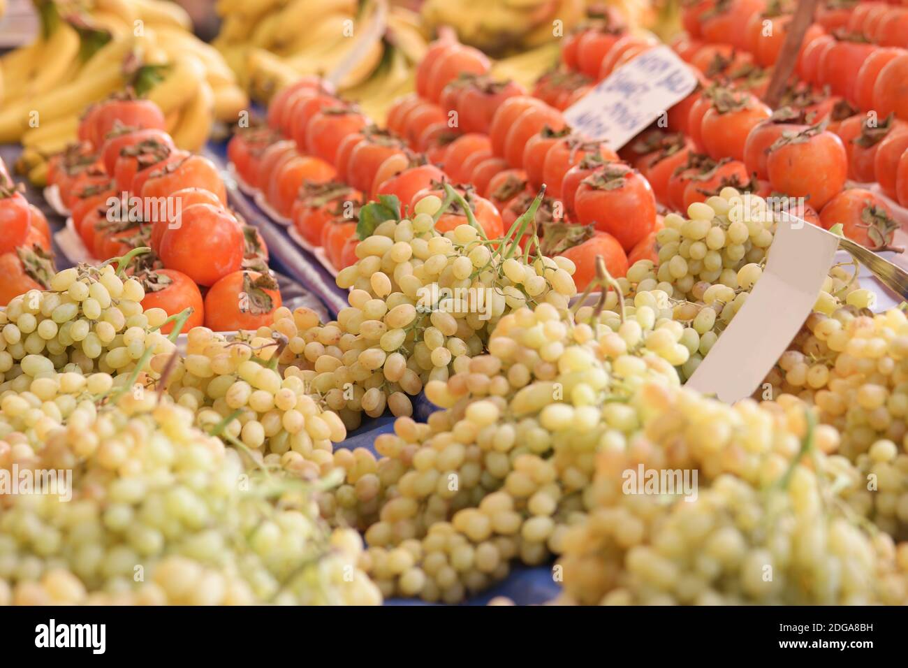 Grapes and persimmons at market stall Stock Photo - Alamy