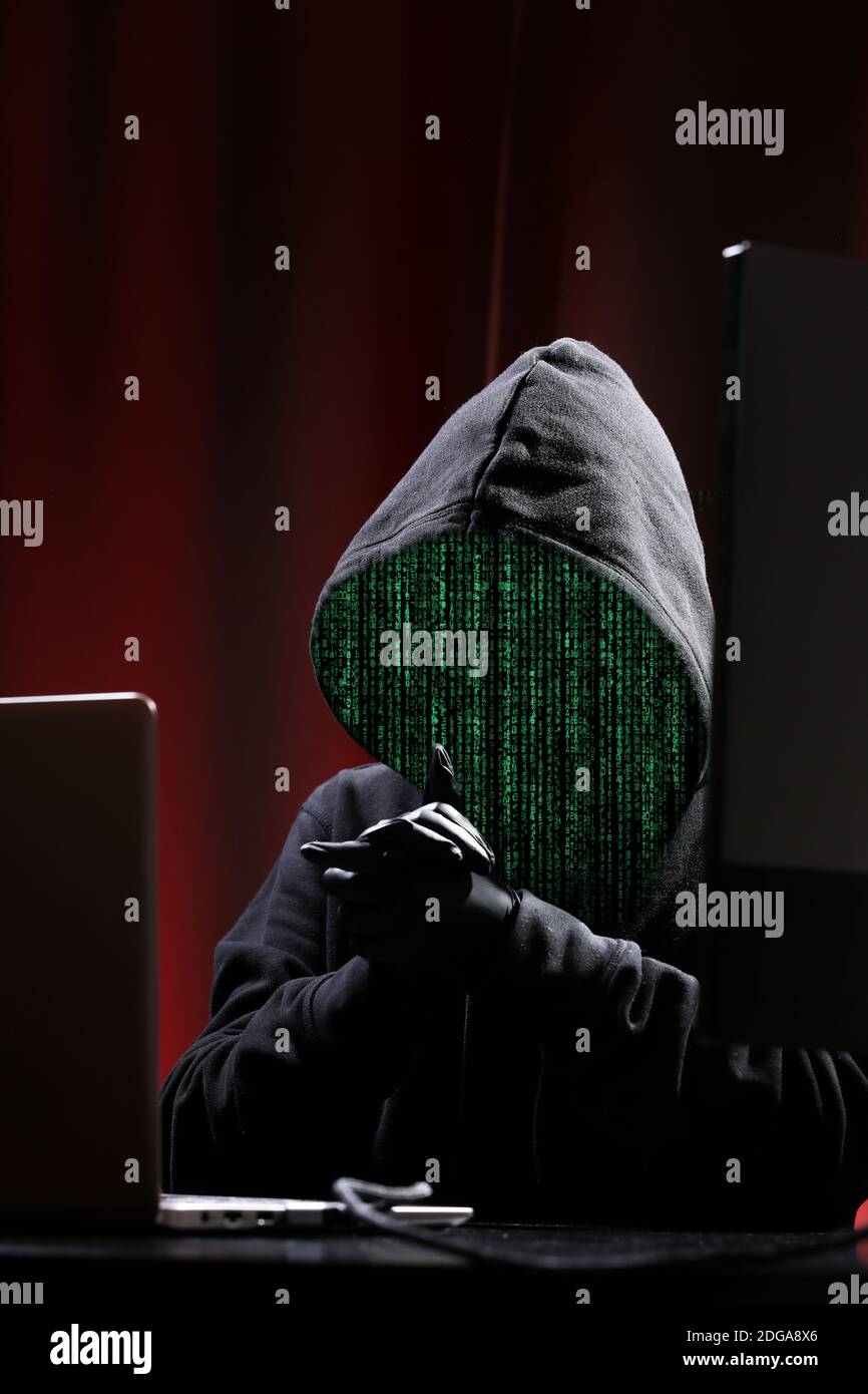 International hacker in black pullover and black mask trying to hack ...