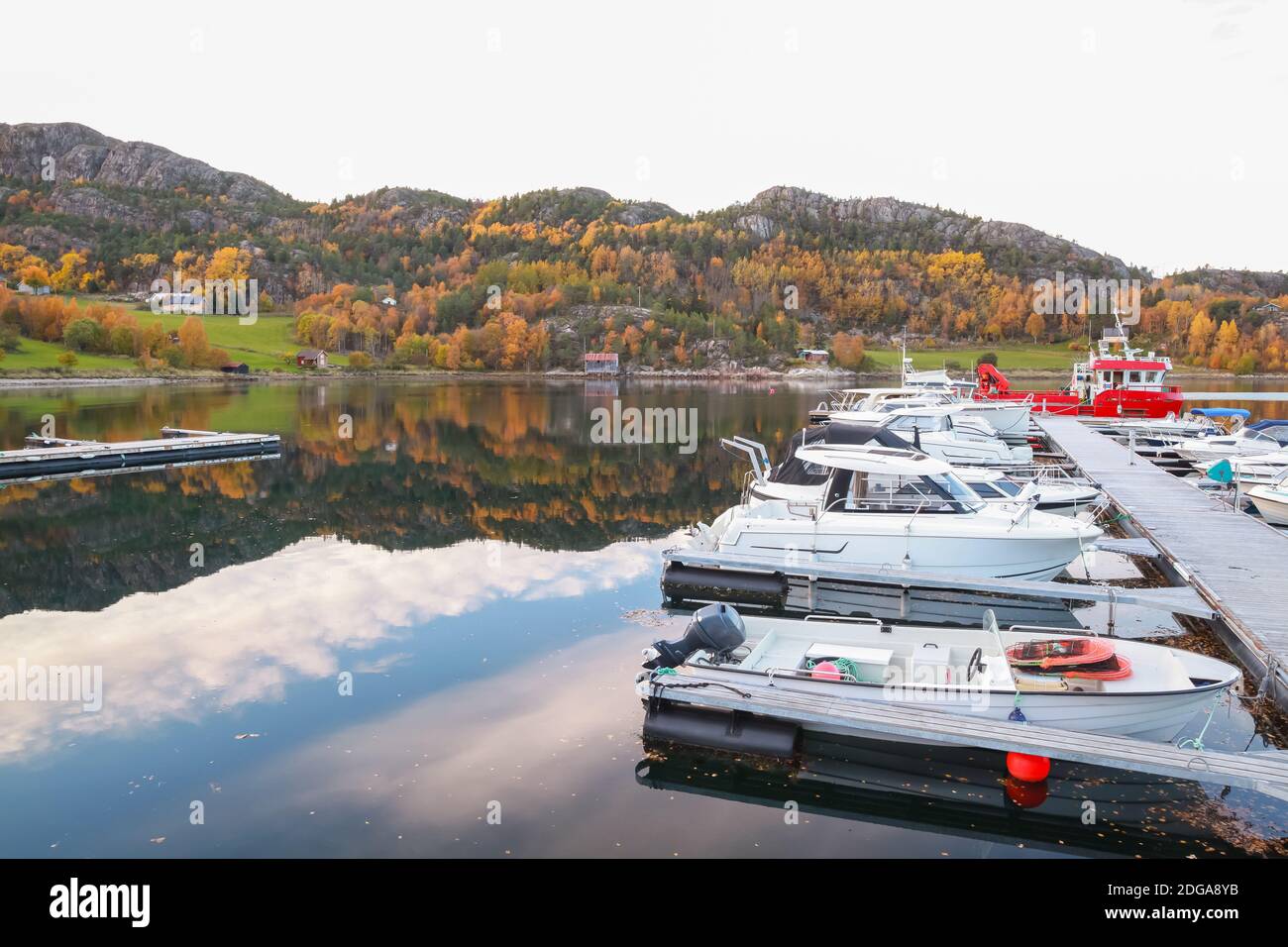 Coastal Norwegian landscape with small boats moored at floating pier ...
