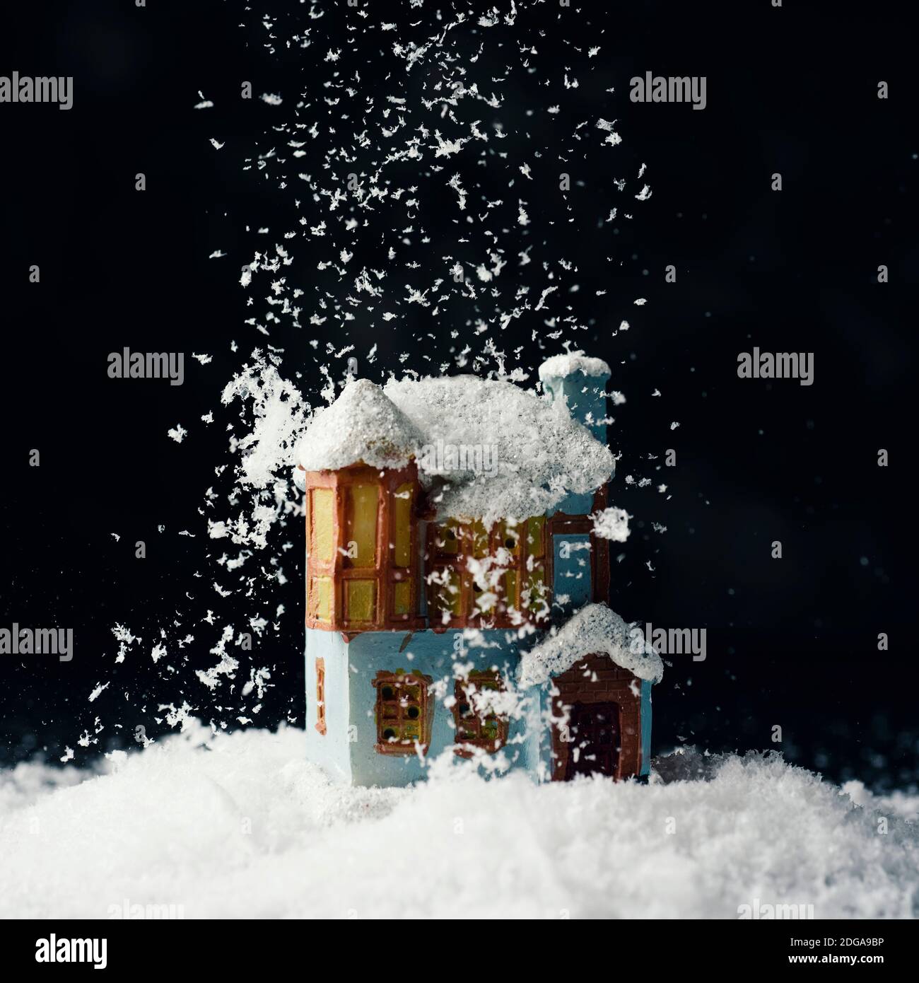 a toy house on the snow while is snowing Stock Photo - Alamy