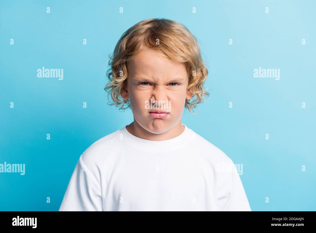 Portrait of little boy with grimace face feel disappointed wear white t ...