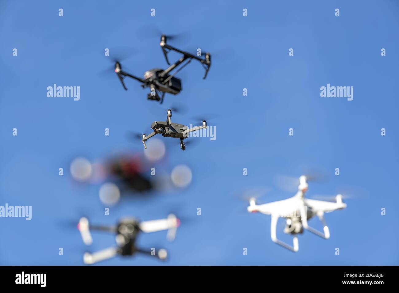 A Group Of Drones Fly Together Through The Air Against A Blue Sky Stock ...