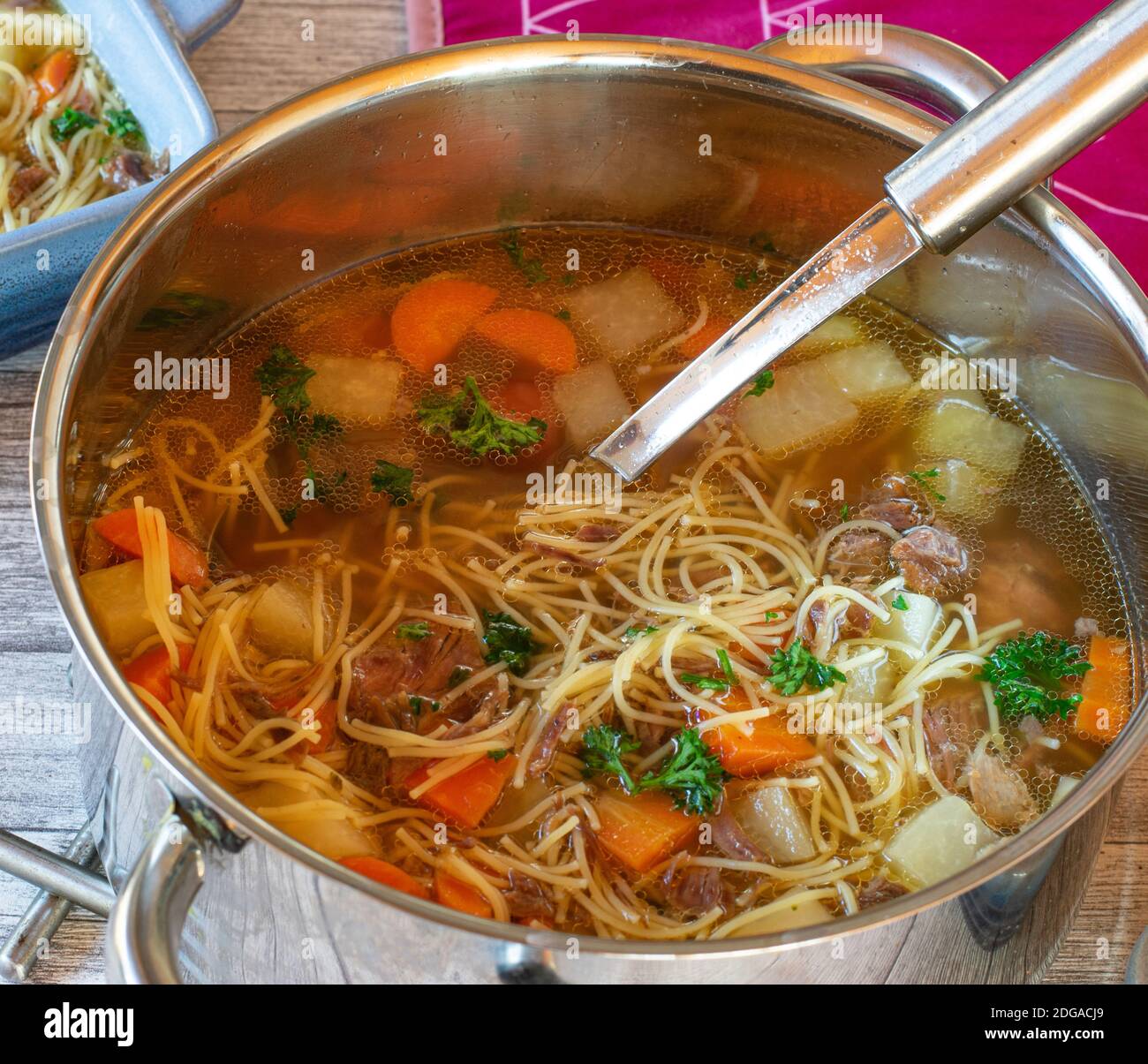 a pot with beef noodle soup from above with ladle Stock Photo - Alamy