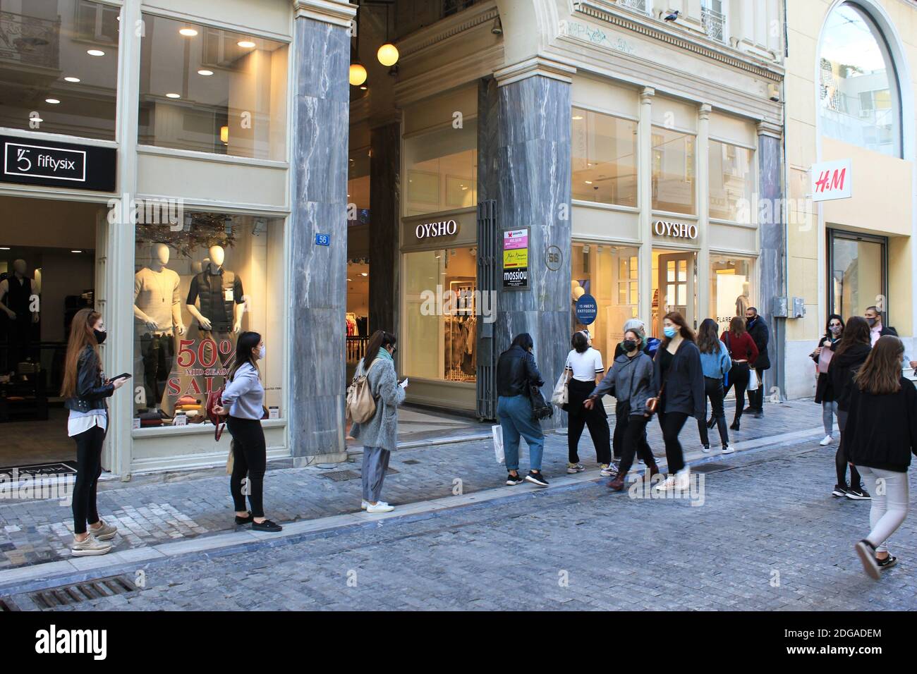 Customers queue to get into clothing stores in the center of Athens ...
