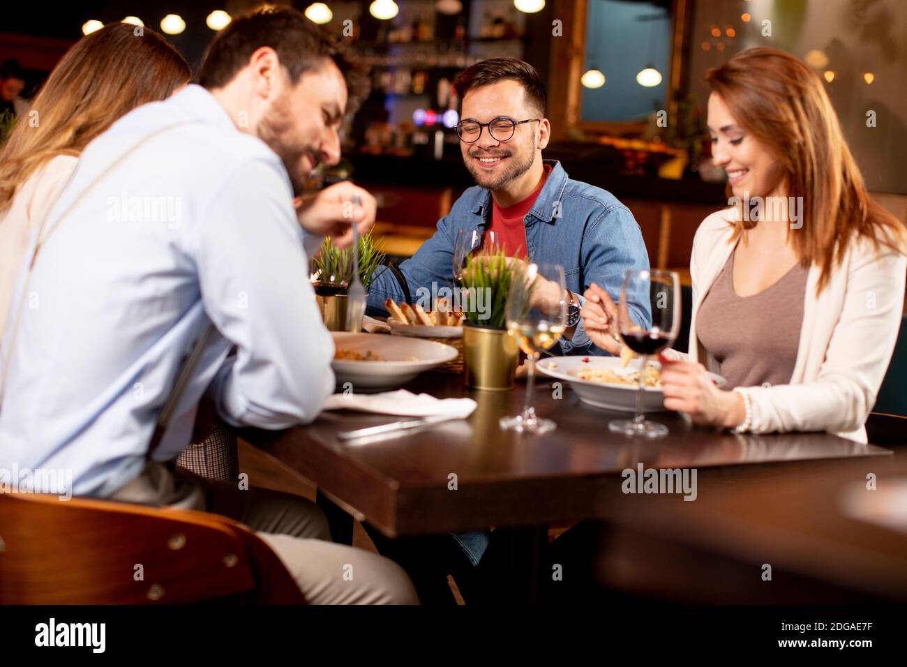 Group of young people having dinner in the restaurant Stock Photo - Alamy