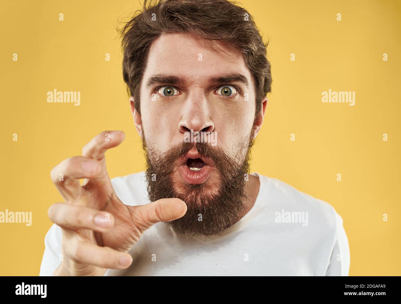 Aggressive man with a beard gestures with his hands near his face on a ...