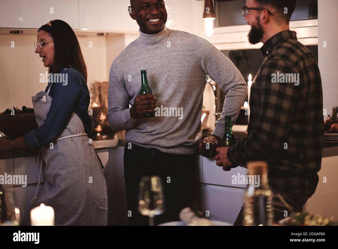 Two male friends laughing together while talking over drinks in a ...