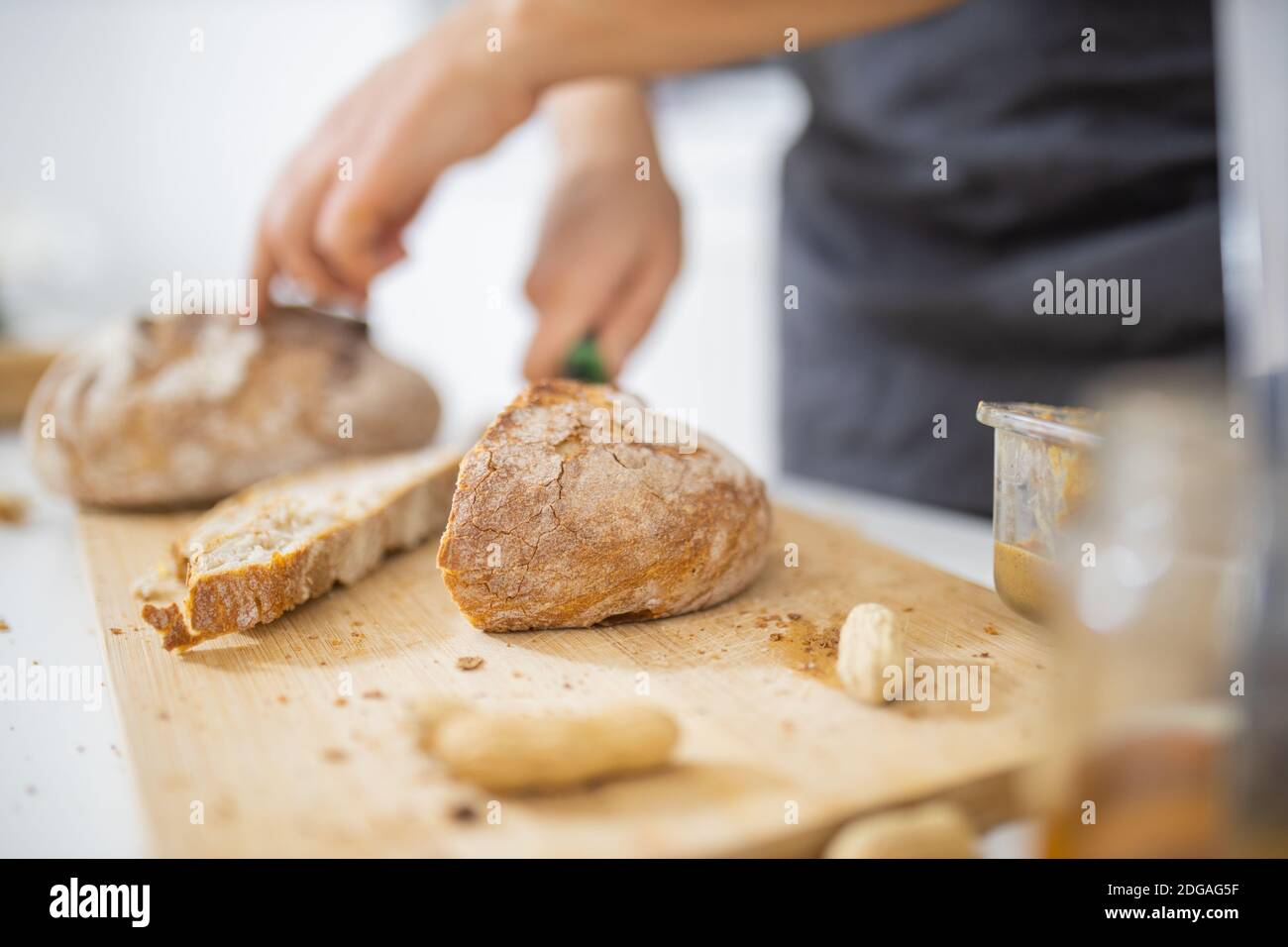 Female hands slicing bread on a cutting board Stock Photo - Alamy