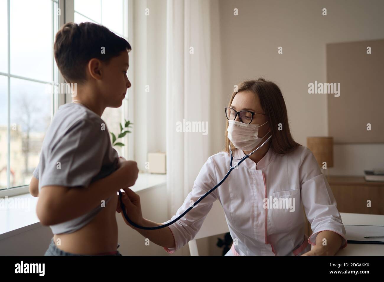Cute boy with pleasure visiting pediatrician, scheduled check up of ...